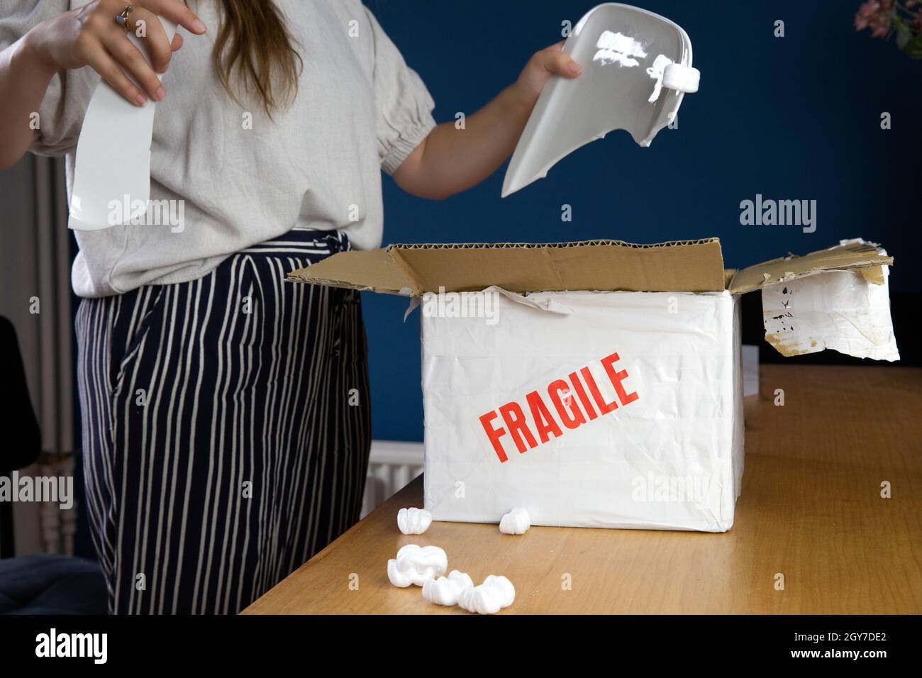 Young woman opening damaged delivery package,online shopping package ...