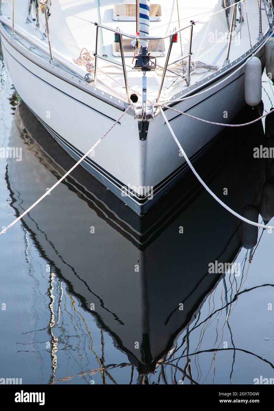 Boat hull at the port reflecting symmetrical in the water Stock Photo ...