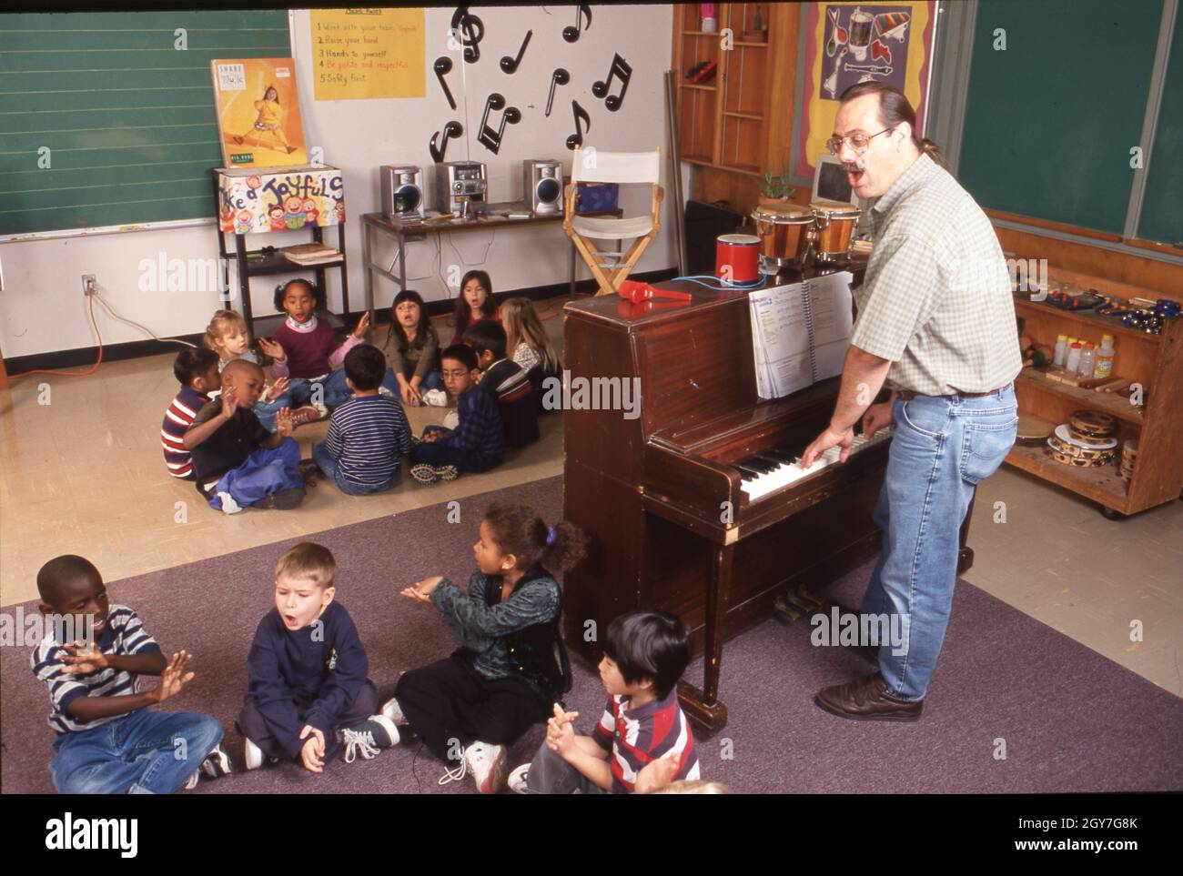 Austin Texas USA, circa 1998: Male music teacher plays piano and sings ...