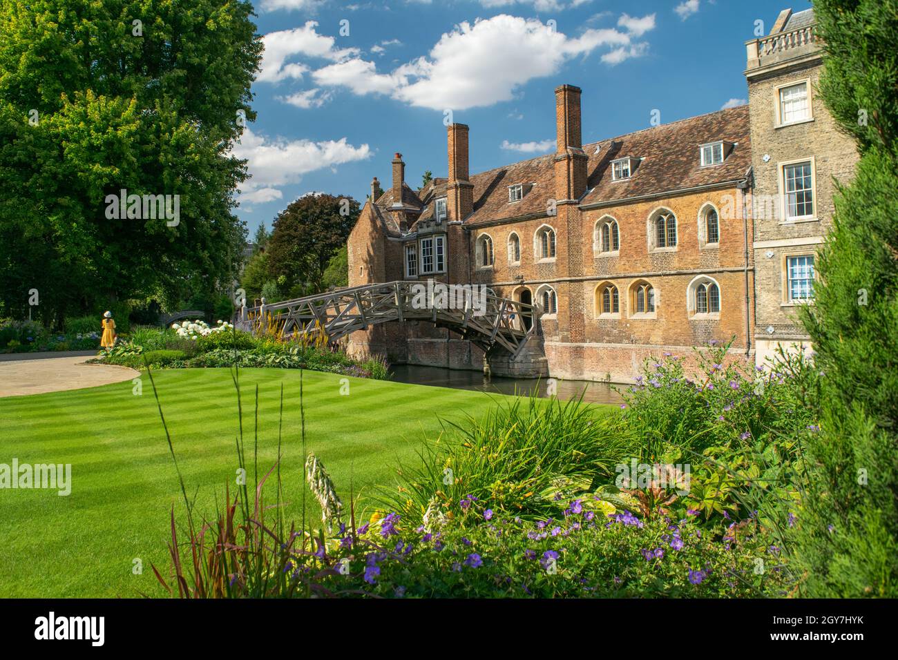 Old wooden bridge over the river connecting terraced houses to a park ...