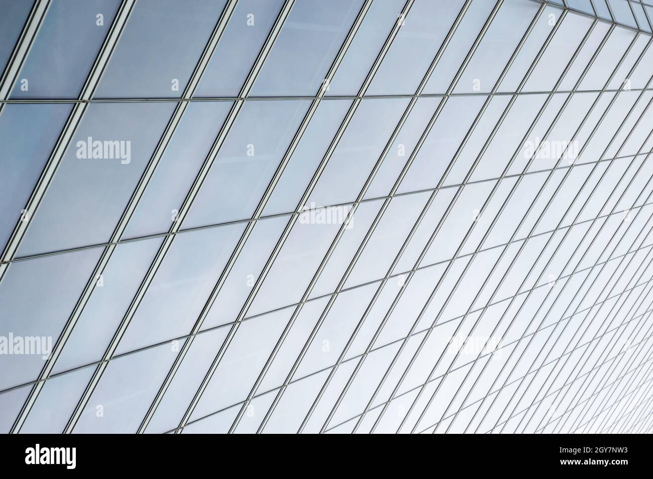 Semi-transparent glass windows of a skyscraper wall, seen from below ...