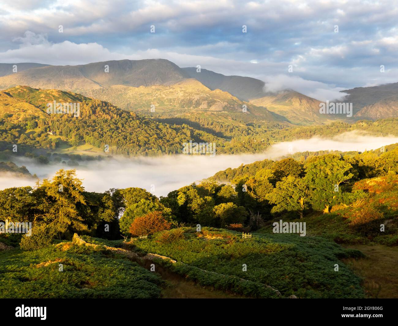 Dawn light over Coniston old Man and Wetherlam, with mist in the ...