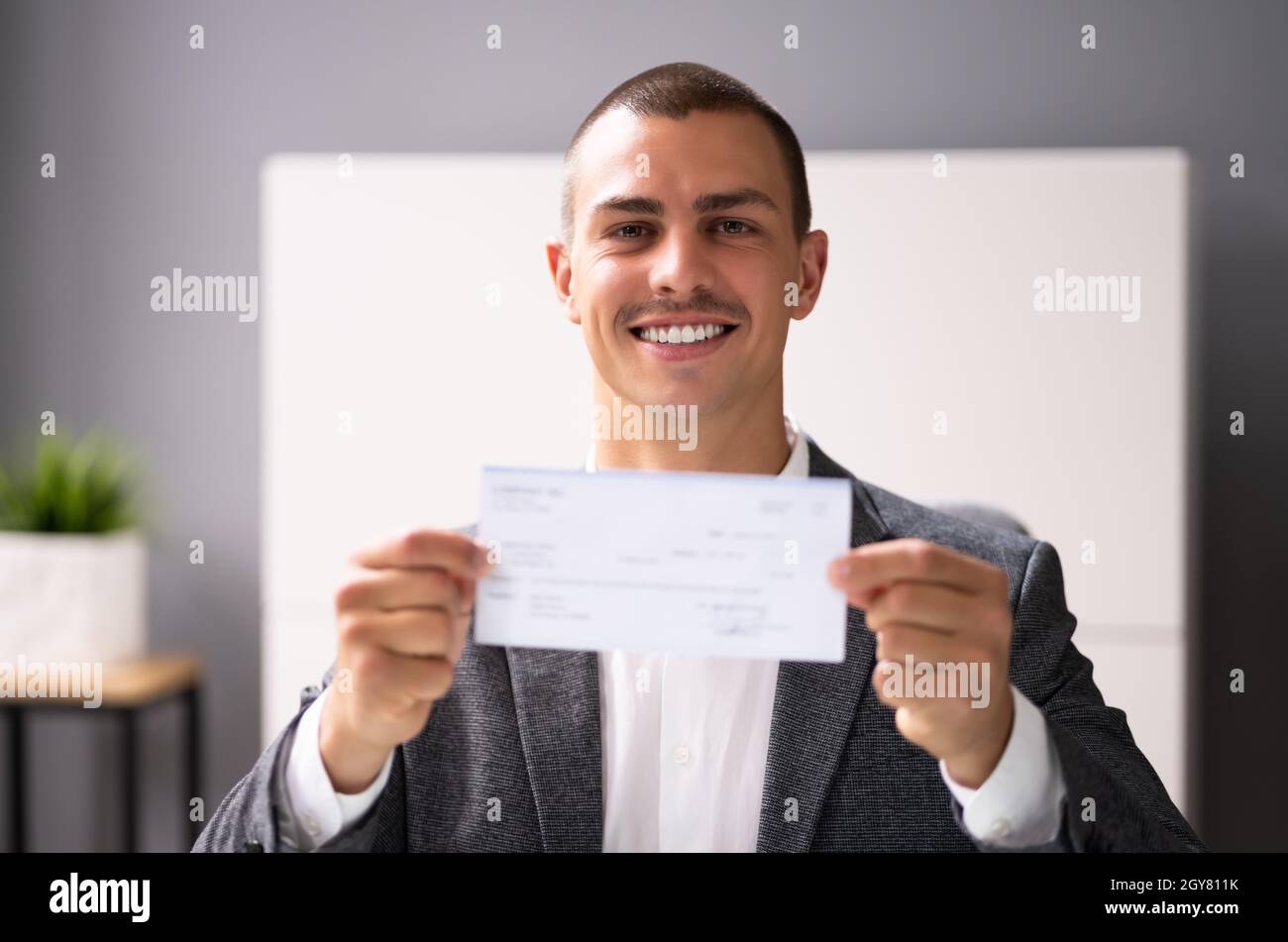 Black Business Man Holding Pay Check Or Paycheck Stock Photo - Alamy