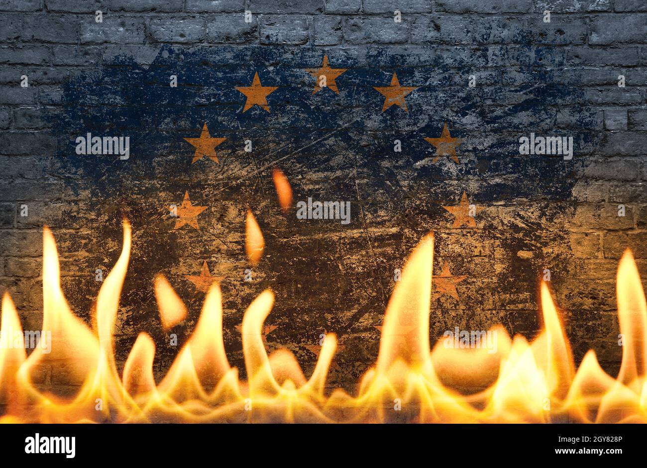 Close up wall with painted European Union EU flag in flames as symbol ...