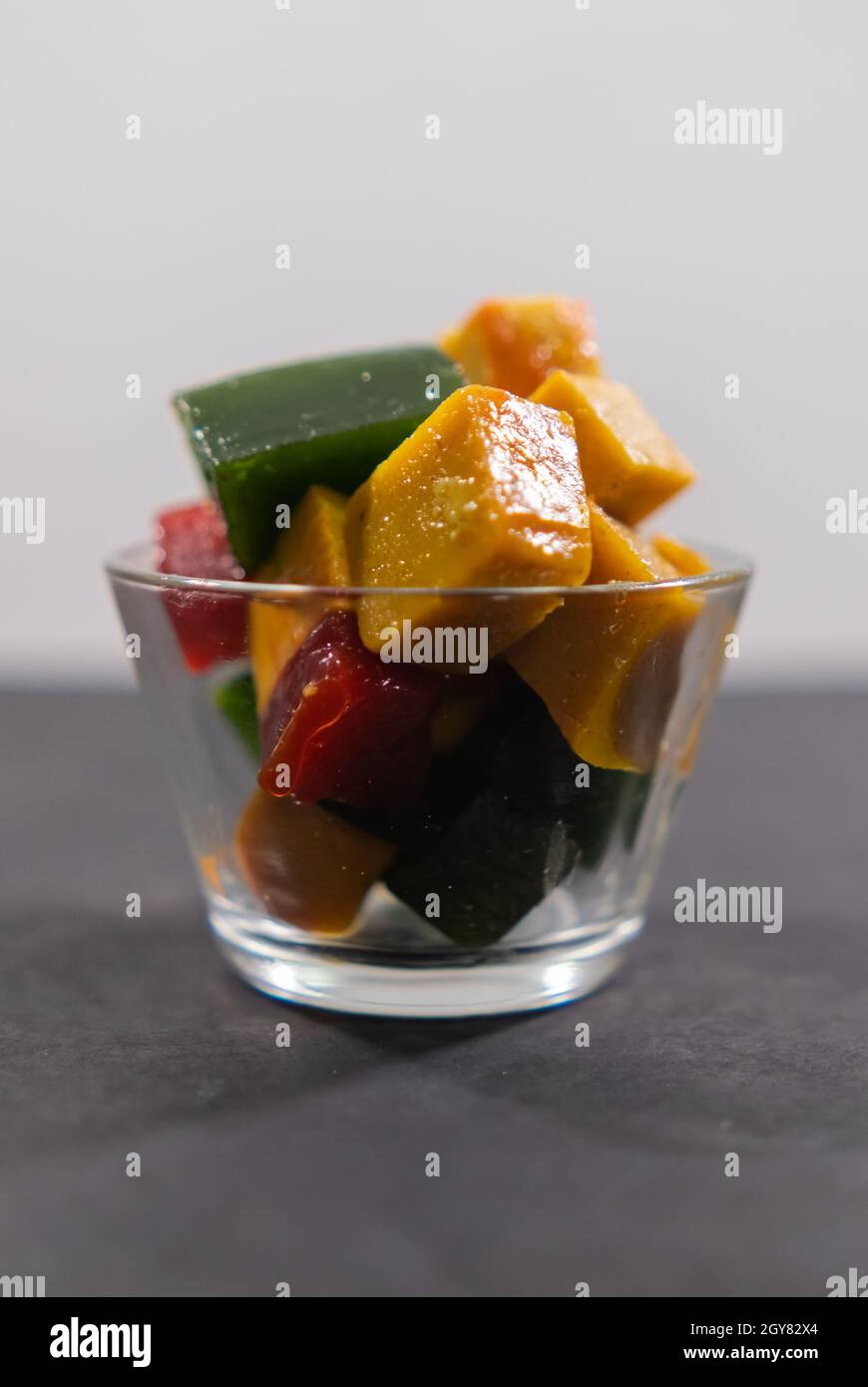 Glass of colorful Mexican fruit paste slices on black surface Stock ...