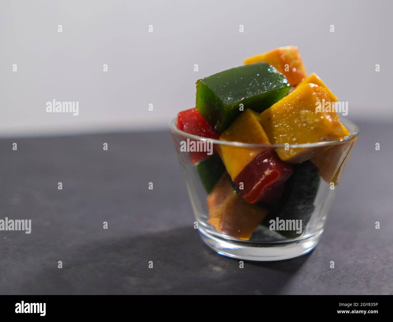 Glass of colorful Mexican fruit paste slices on black surface Stock ...