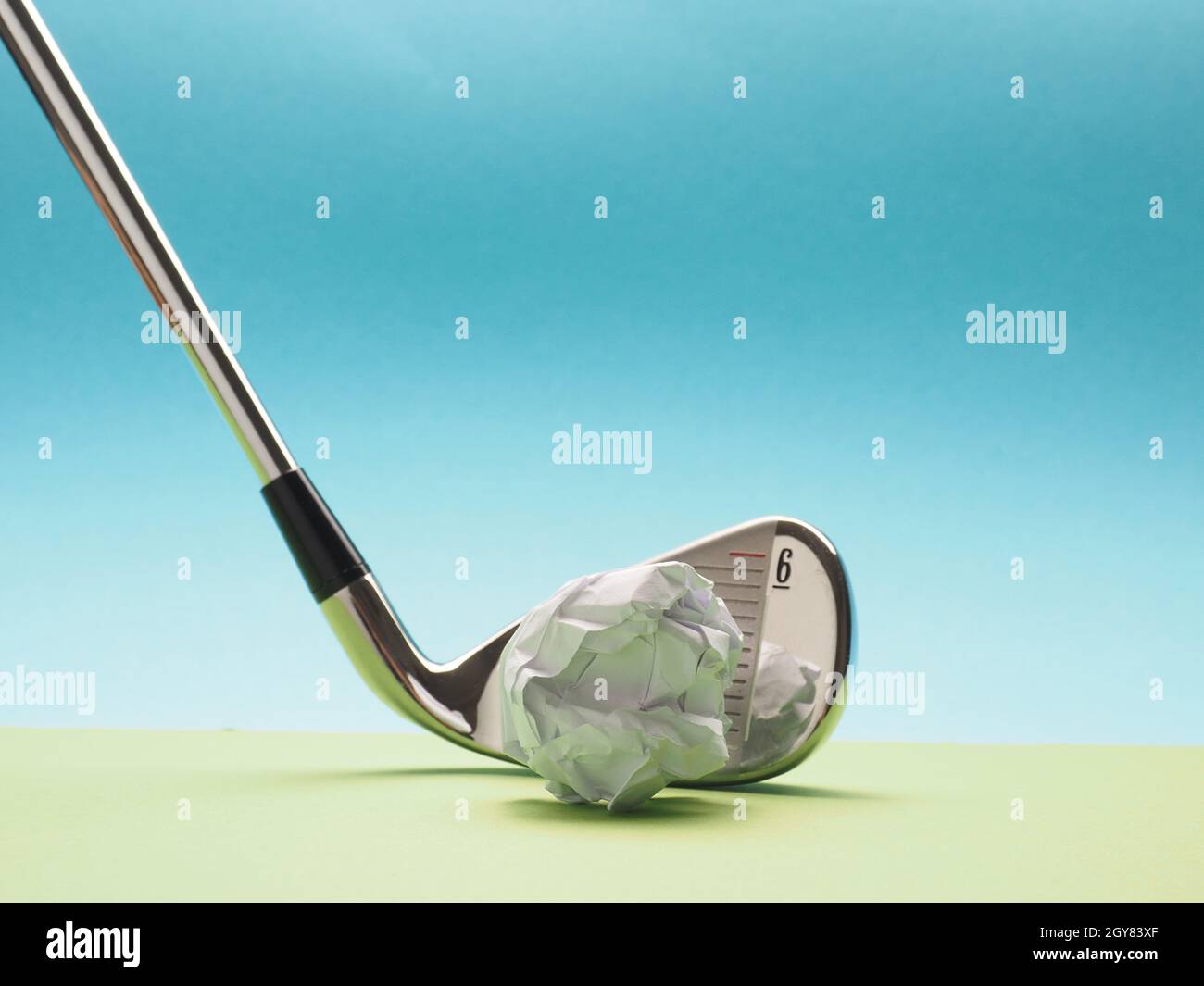 Golf club with a crumpled paper ball as golf ball, New ideas or ...