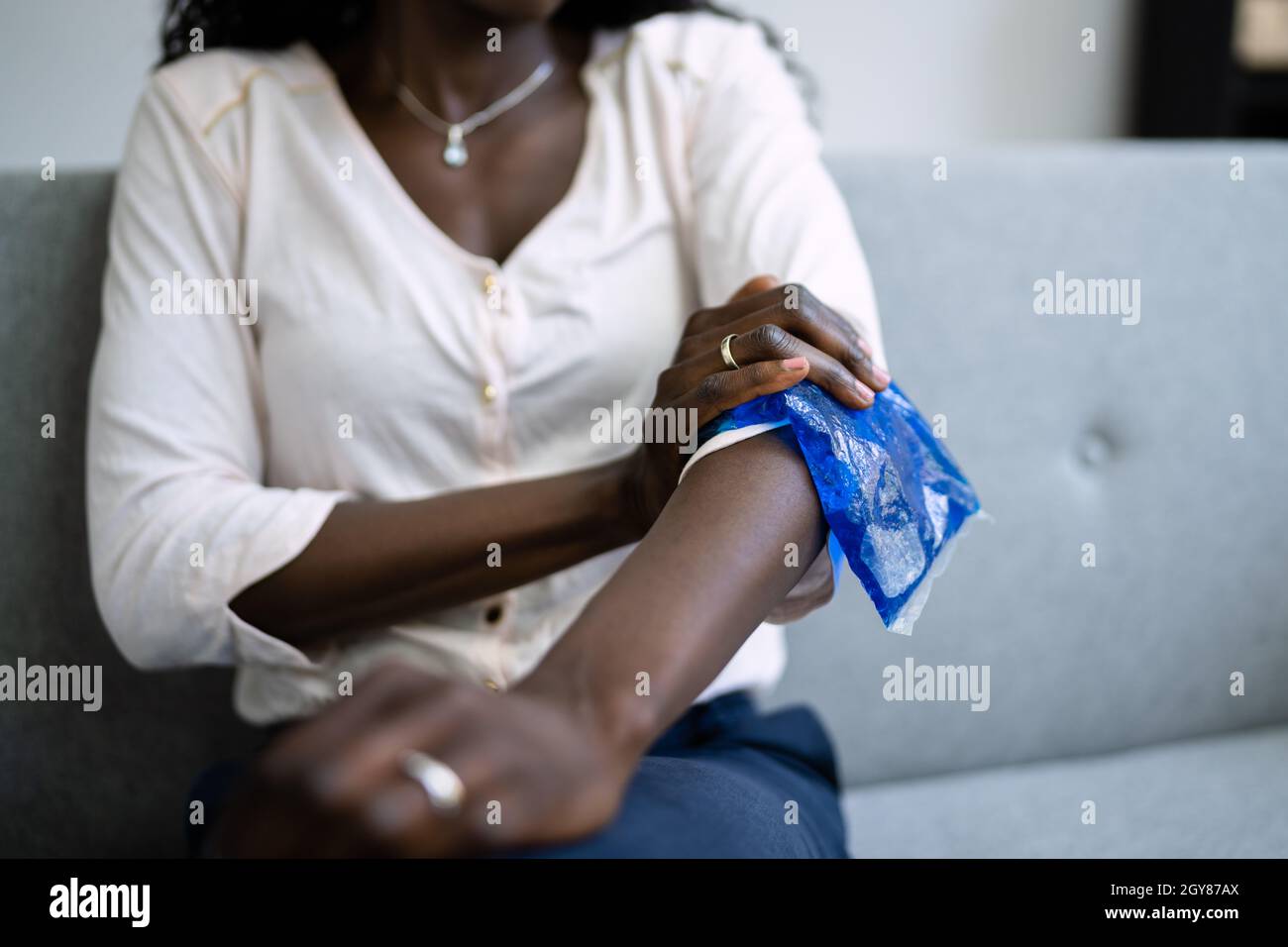 Woman Using Ice Gel Pack On Injured Arm Stock Photo - Alamy