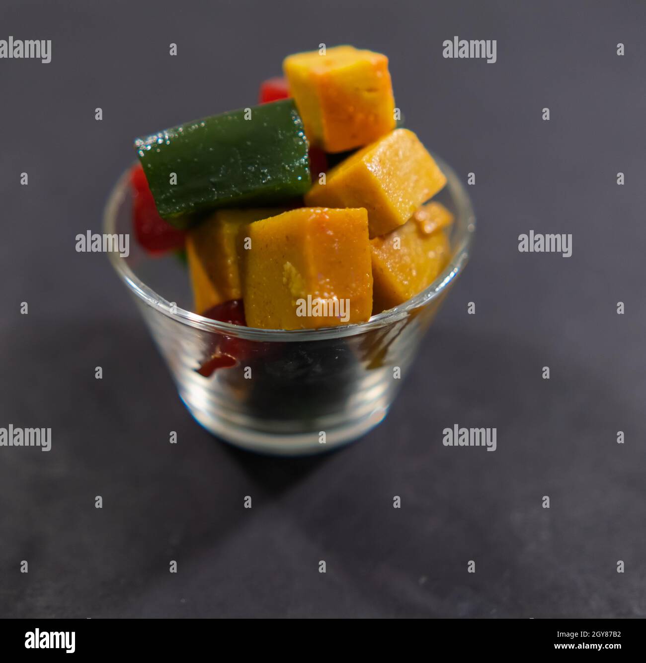 Glass of colorful Mexican fruit paste slices on black surface Stock ...