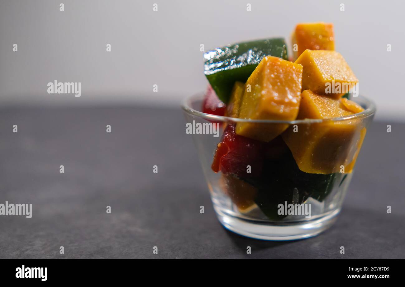 Glass of colorful Mexican fruit paste slices on black surface Stock ...
