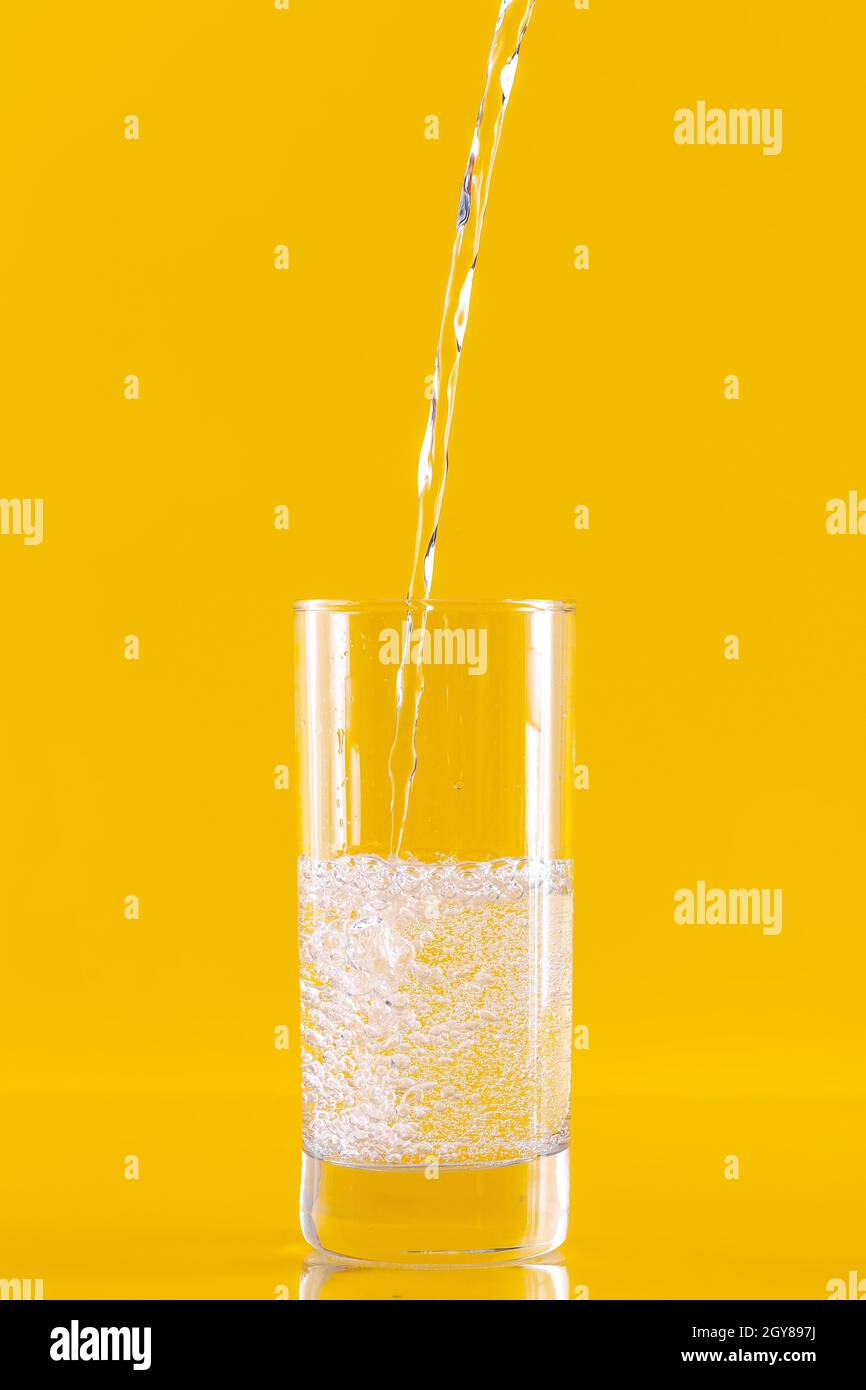 Cold water pouring from a bottle into a glass Stock Photo - Alamy