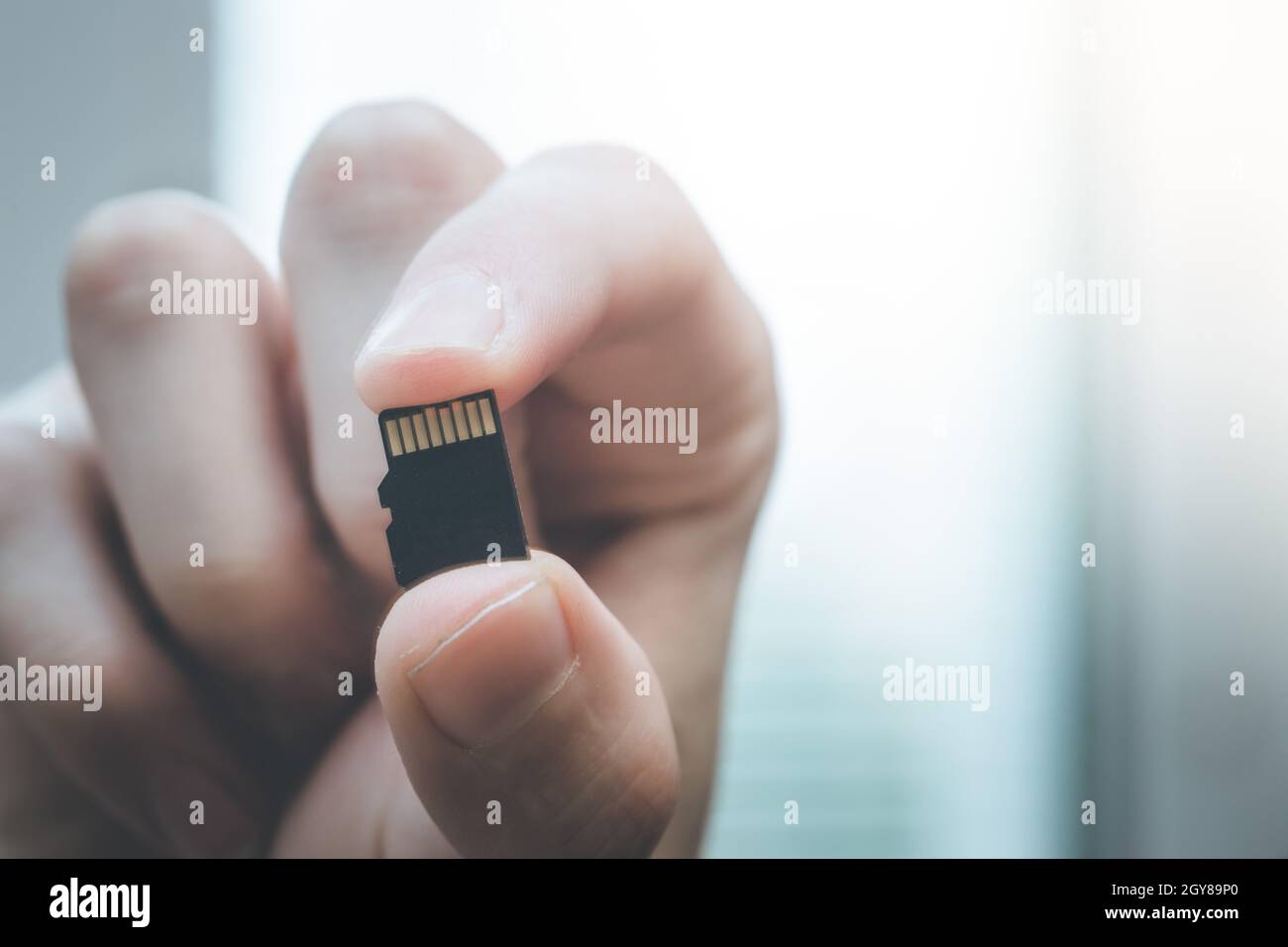 Young man is holding a tiny memory card in his hand, text space Stock ...