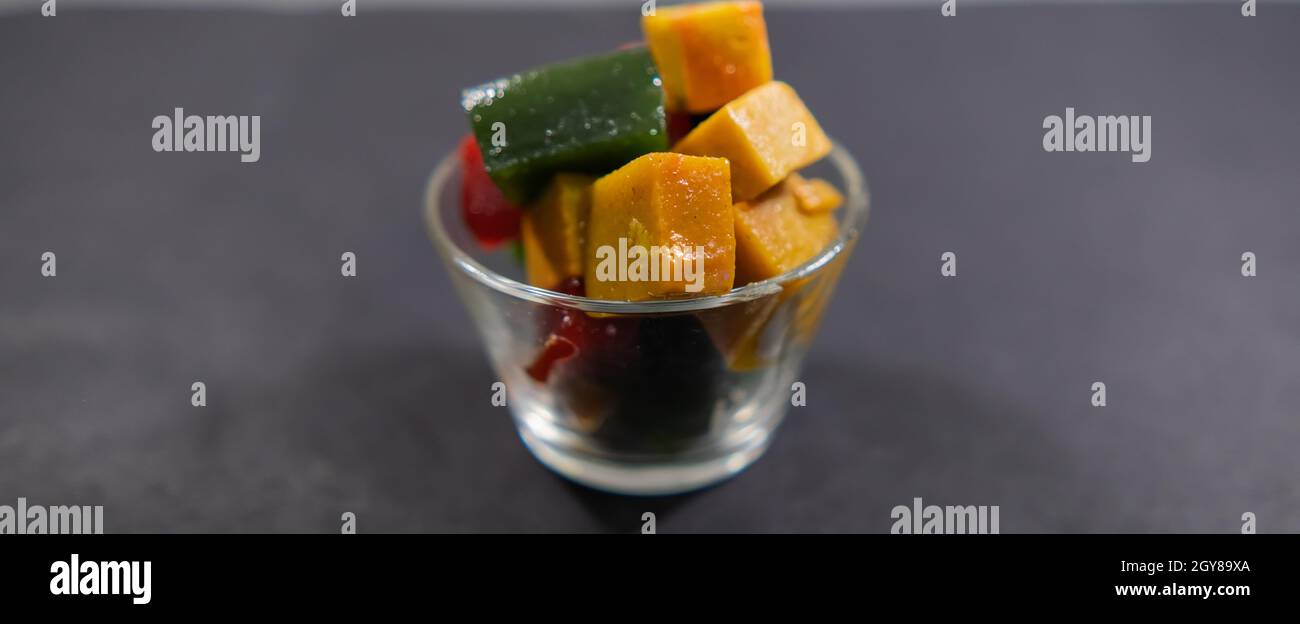 Glass of colorful Mexican fruit paste slices on black surface Stock ...