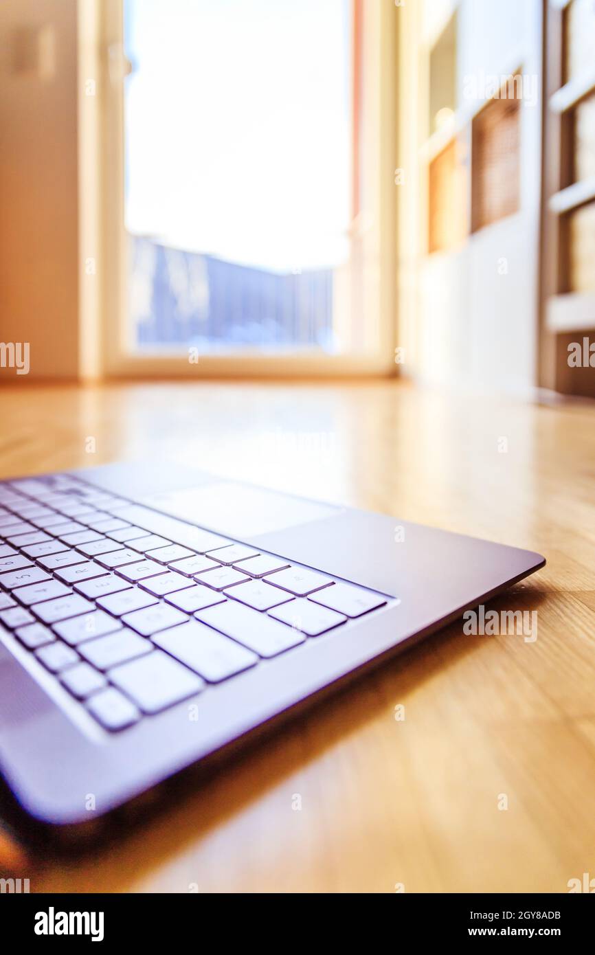 Cutout of a modern laptop keyboard on the wooden floor with text space ...