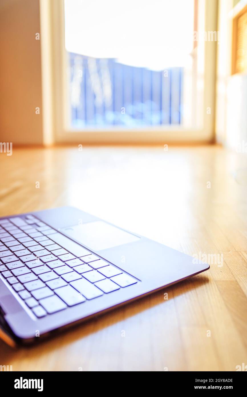 Cutout of a modern laptop keyboard on the wooden floor with text space ...