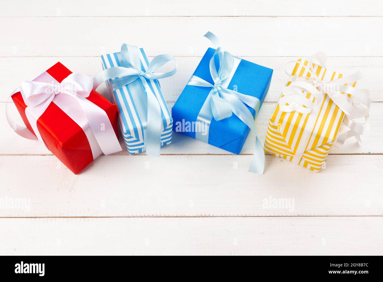 White wooden table with wrapped gifts top view Stock Photo - Alamy