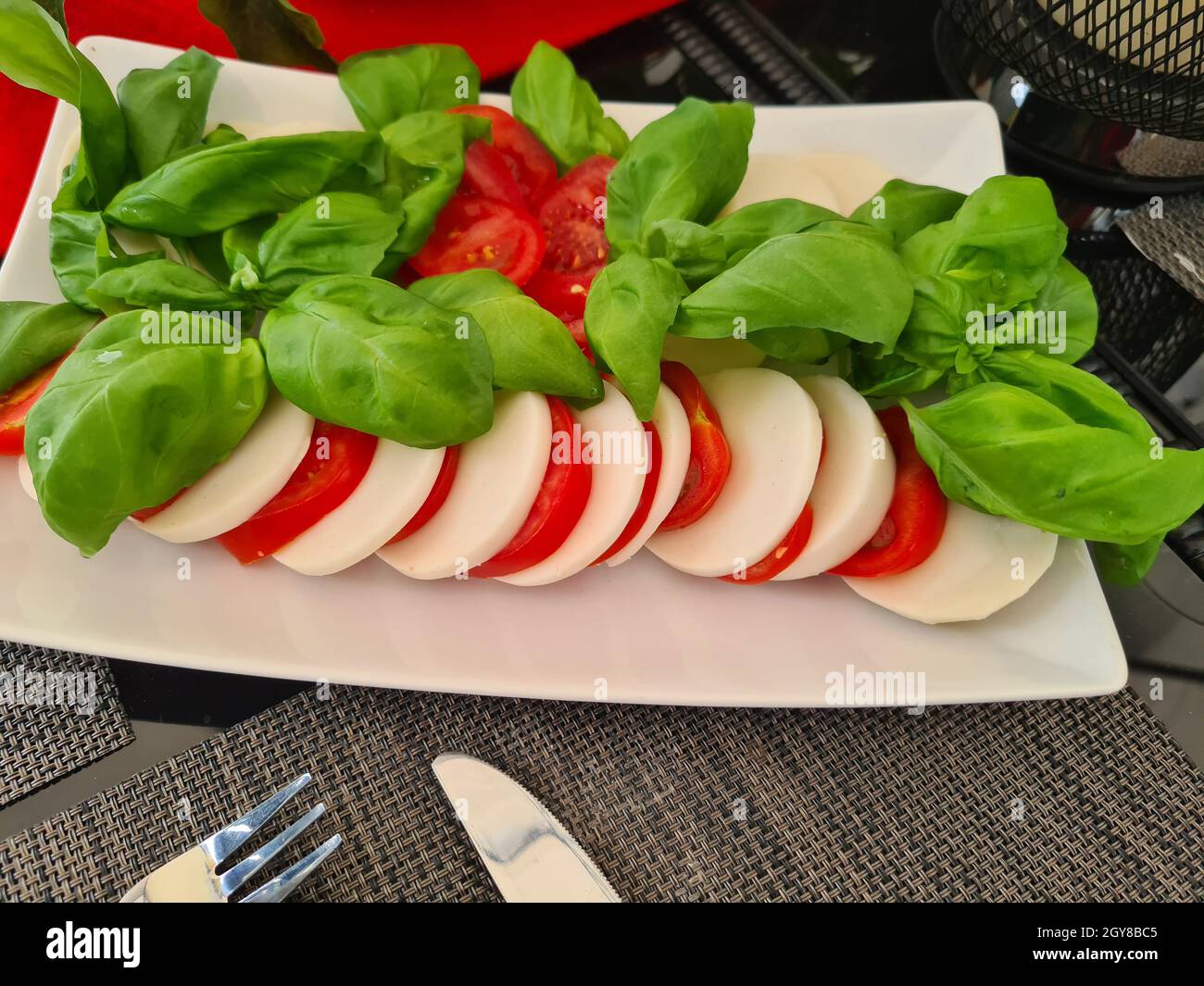 Mozzarella and tomato salad - caprese on the blue plate Stock Photo - Alamy