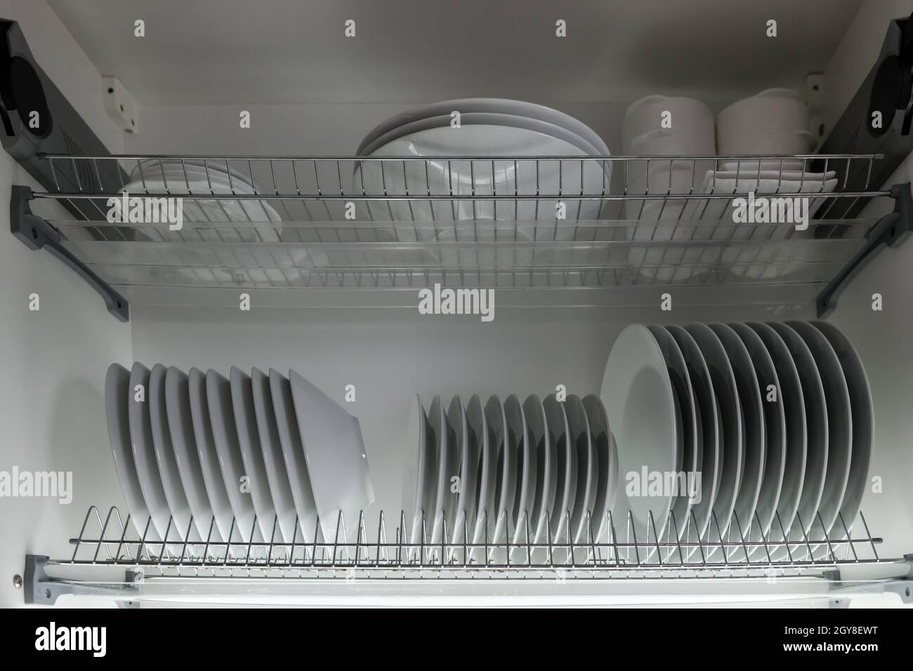 Set of different plates on the shelf in the kitchen cabinet. Kitchen ...