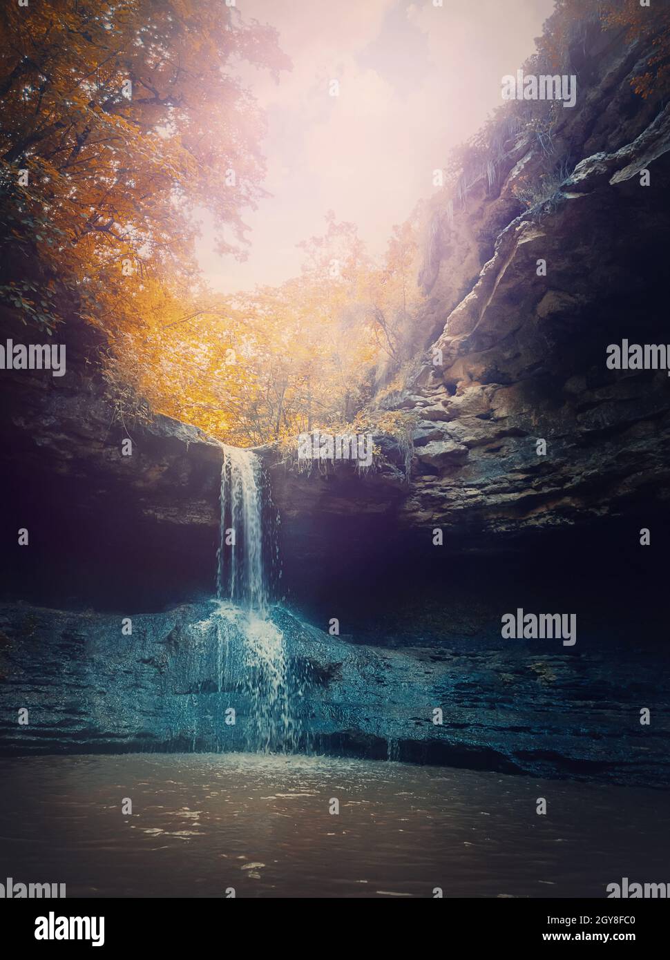 Small creek waterfall with water falling through the stone cave. Fast ...