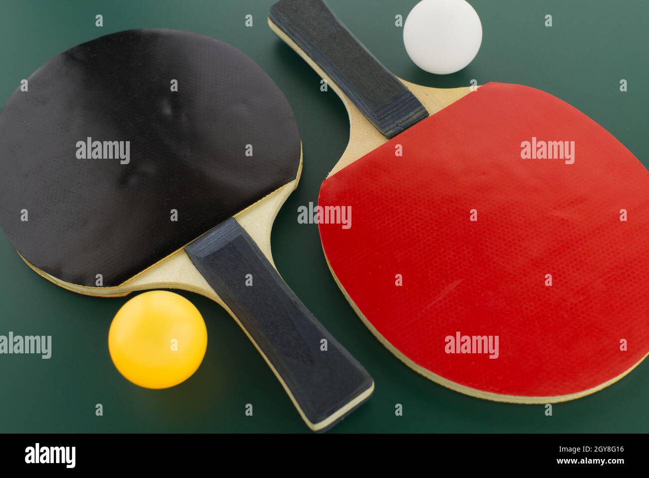 Two table tennis racks with a white and an yellow ping pong ball on ...