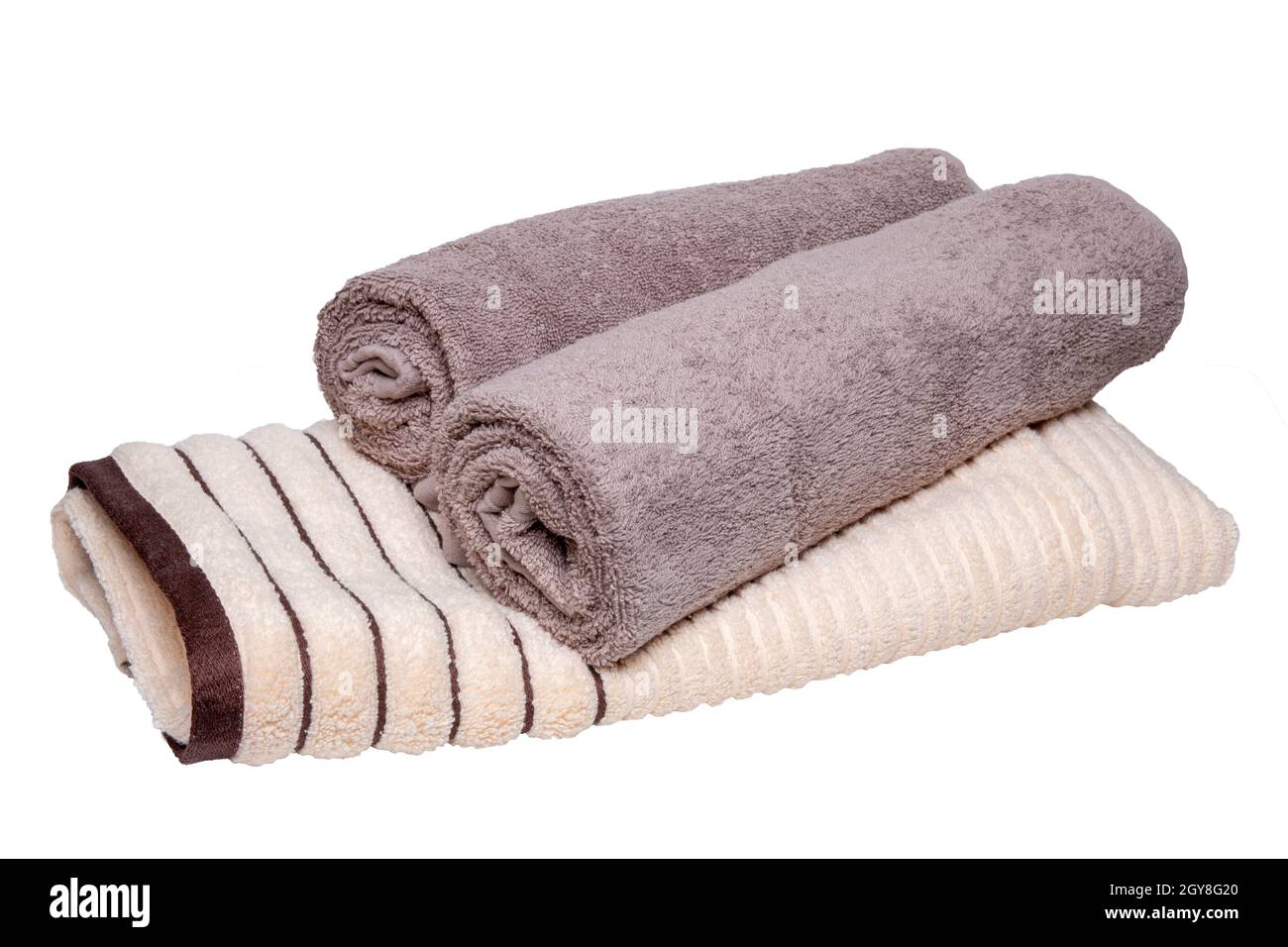 Towels isolated. Closeup of a stack or pile of brown beige soft terry ...