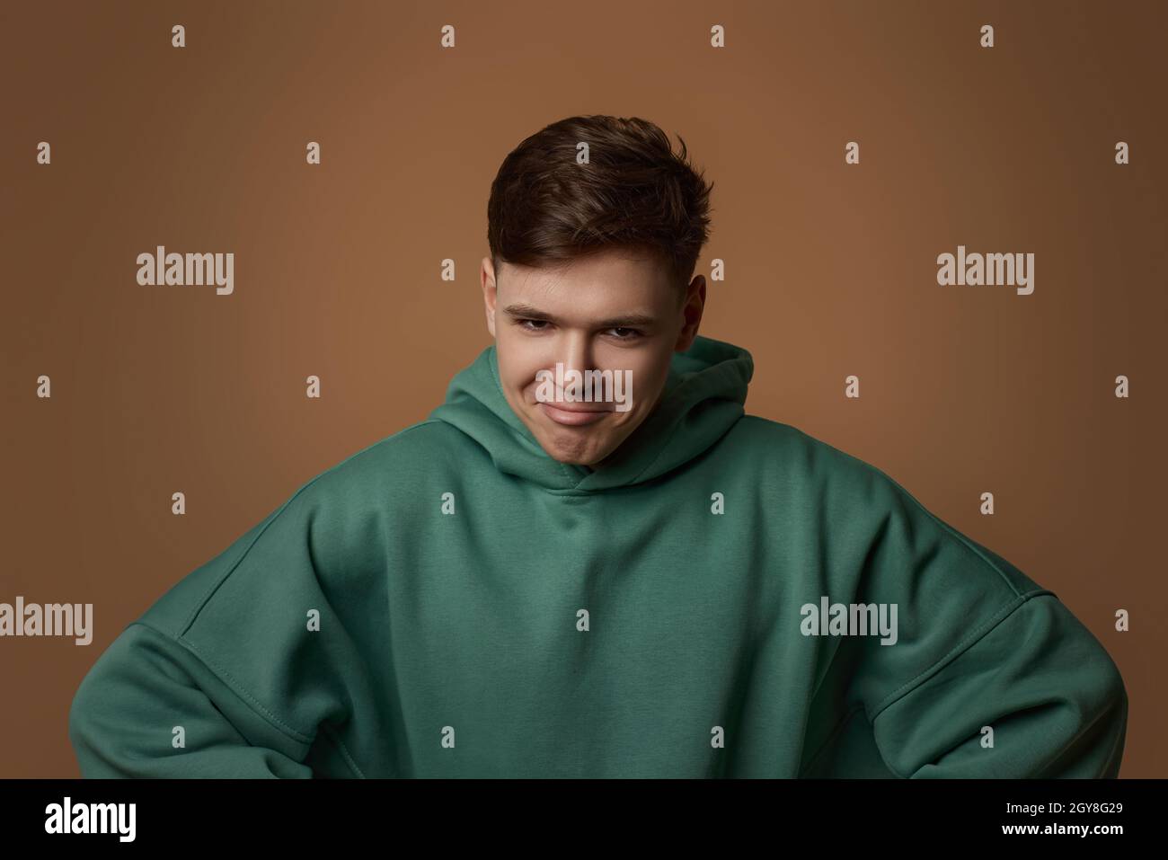 young man frowning isolated on brown background. Human emotions, facial ...