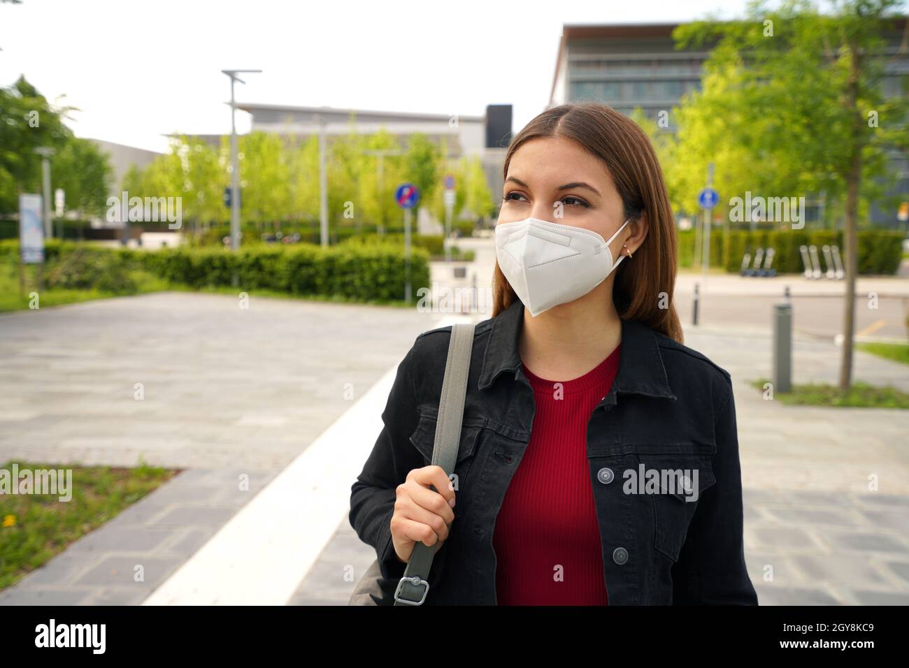 Portrait of young woman wearing FFP2 KN95 protective mask walking in ...