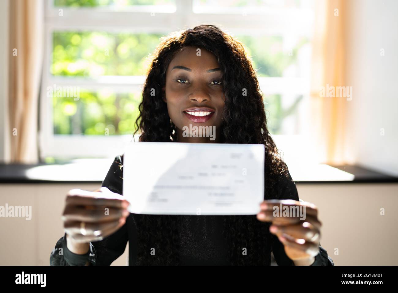 Black Business Woman Holding Pay Check Or Paycheck Stock Photo - Alamy