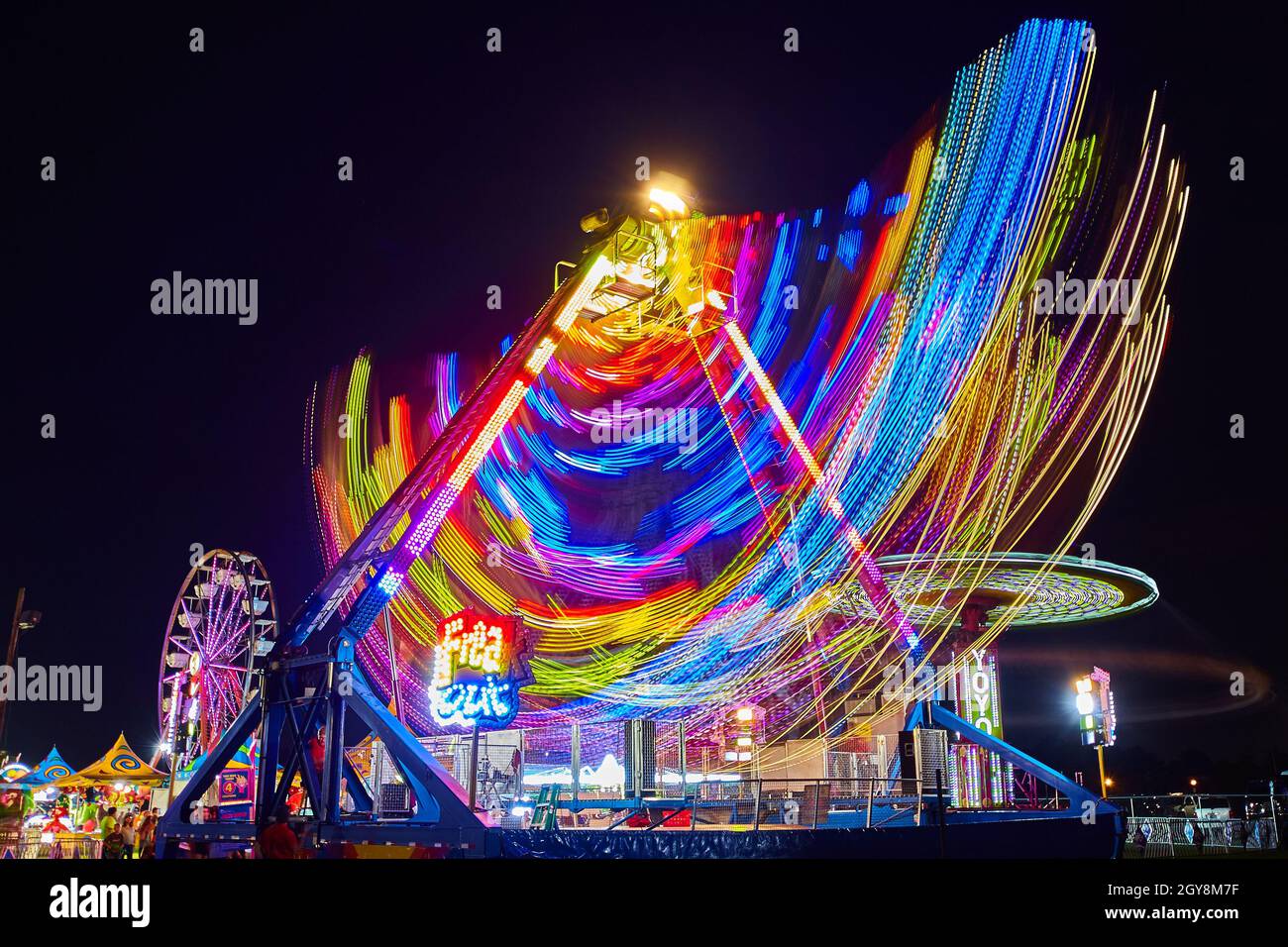 Fair rides and carnival rides at night with colors and motion Stock ...