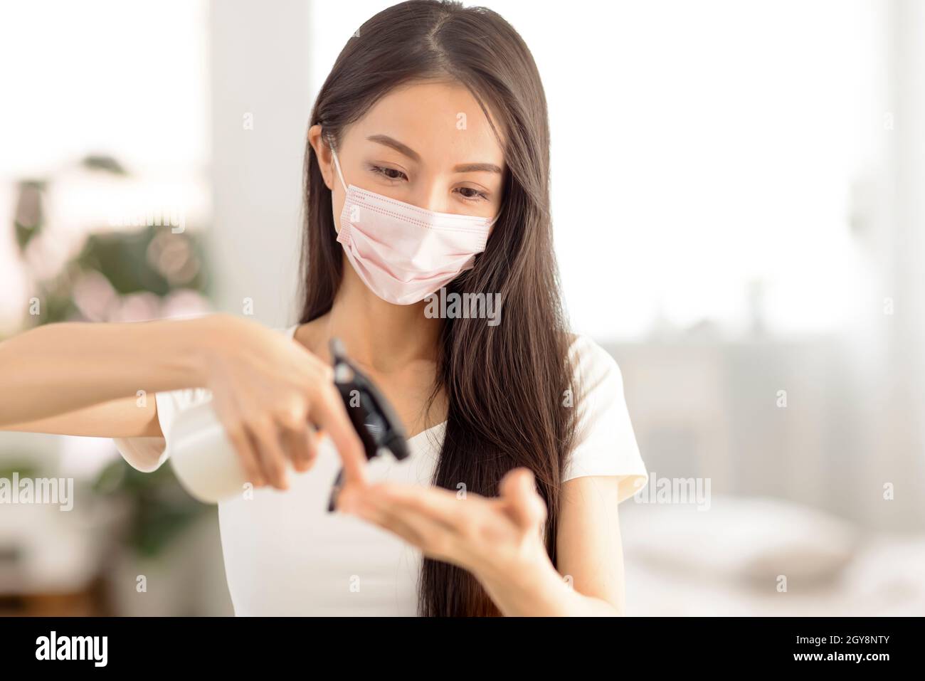 Young woman wearing safety mask and using disinfection spray Stock ...