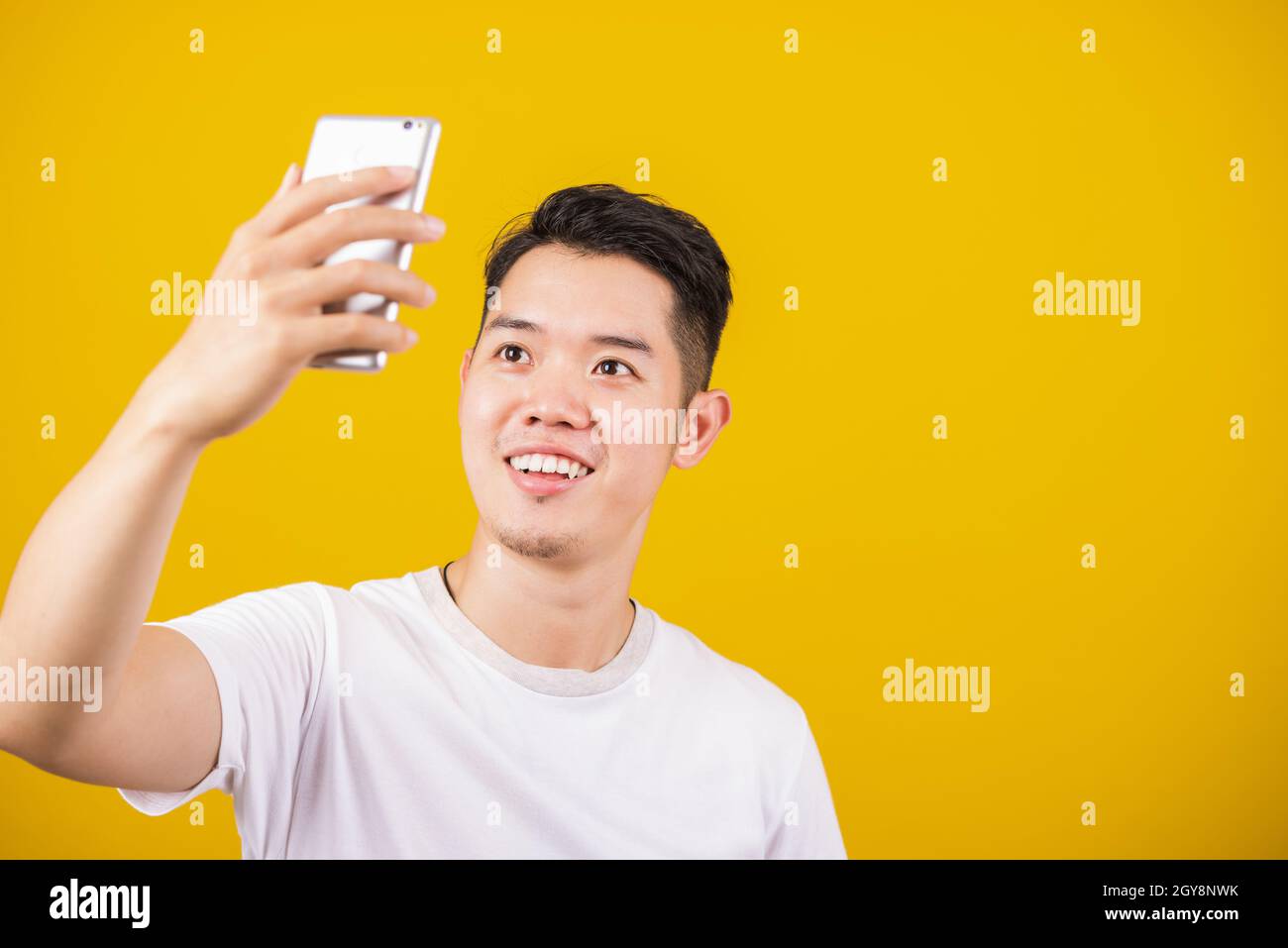 Asian handsome young man smiling positive saying hi talking by video ...