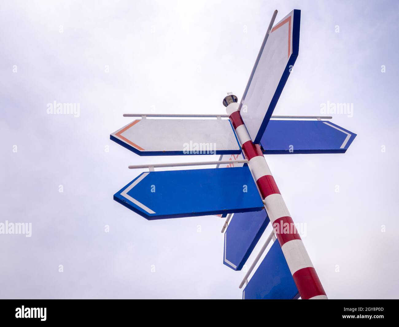High Blank directional road signs over blue sky Stock Photo - Alamy