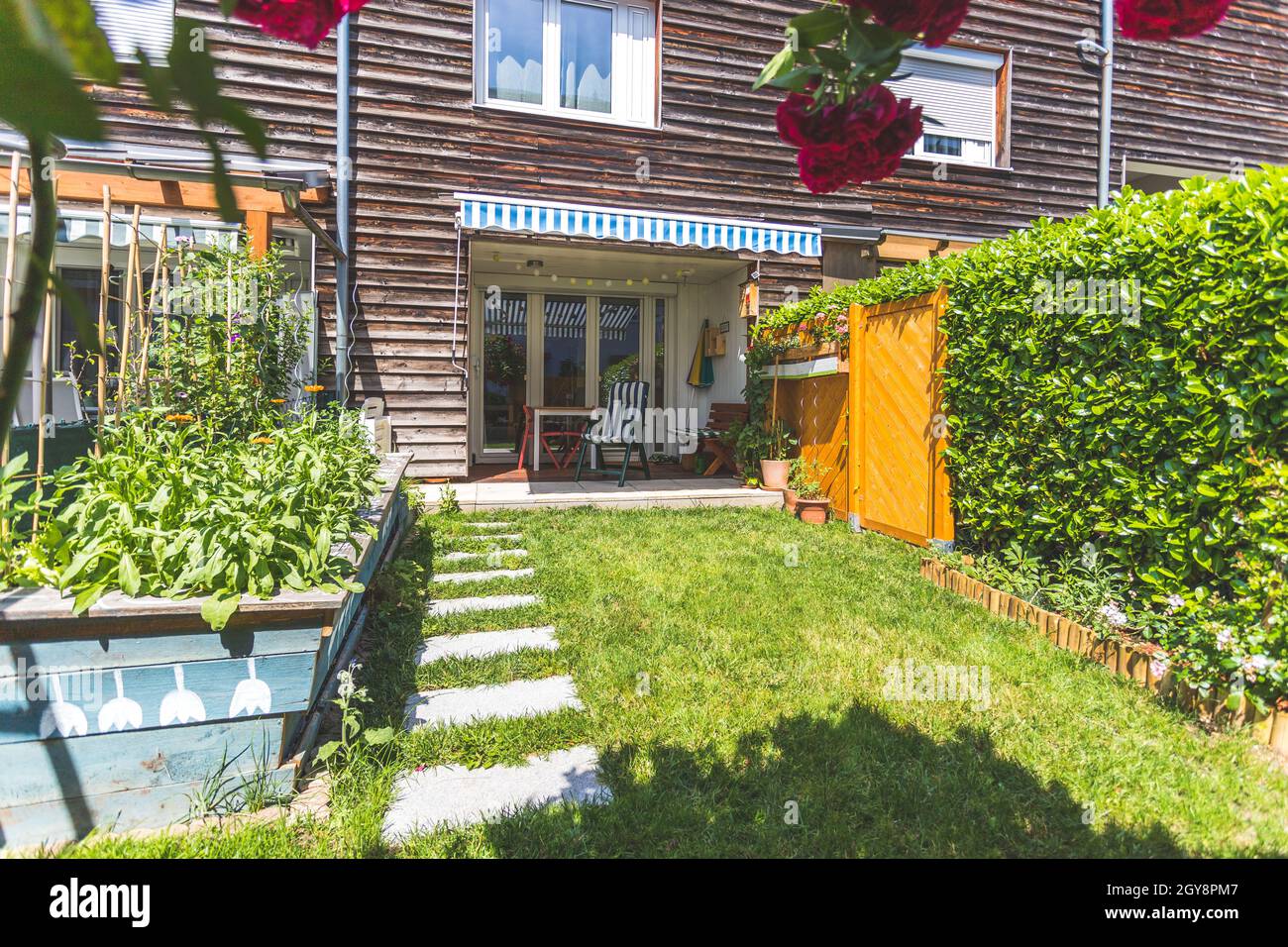 Cozy little green garden with raised bed and veranda, summer time Stock ...
