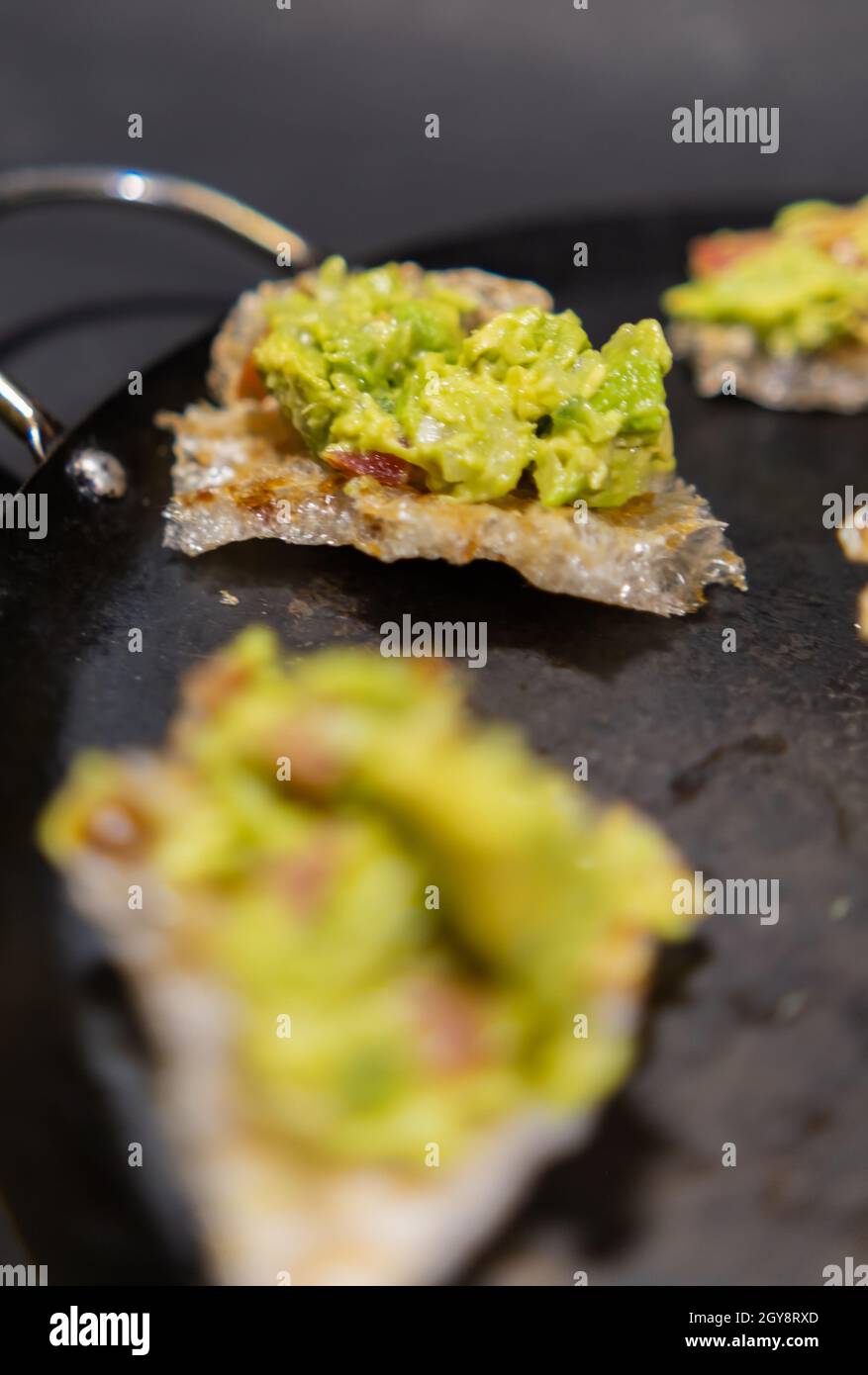 Pork rinds with guacamole on traditional Mexican comal Stock Photo - Alamy