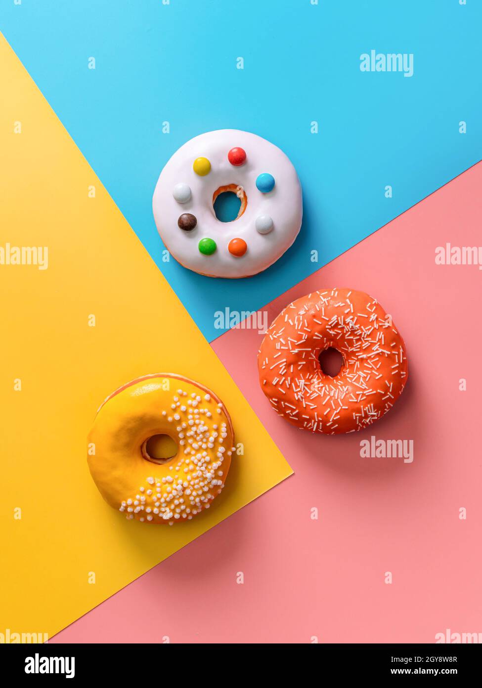 Creative layout made from delicious glazed donuts. Vertical flat lay ...
