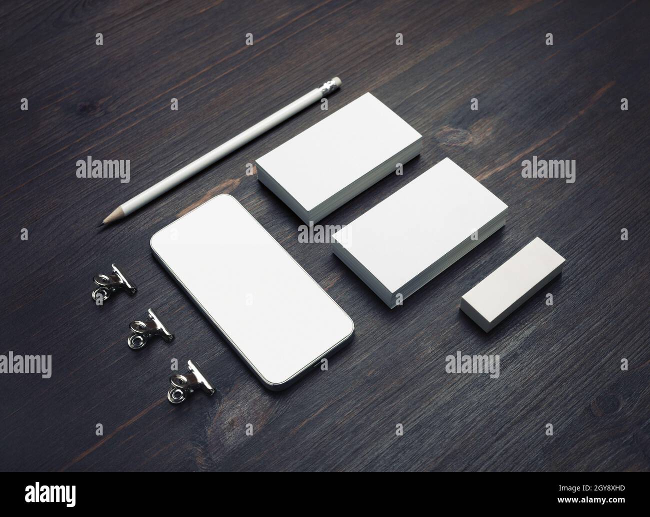 Smartphone, blank business cards, pencil and eraser on wood table ...