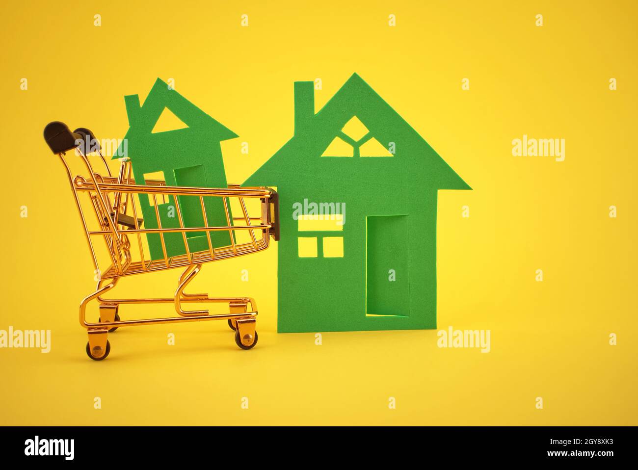 Buy real estate concept with house and shopping cart over yellow ...