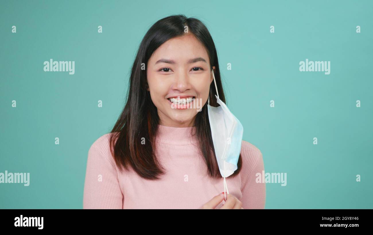 Portrait young Asian happy beautiful woman take off protective face ...
