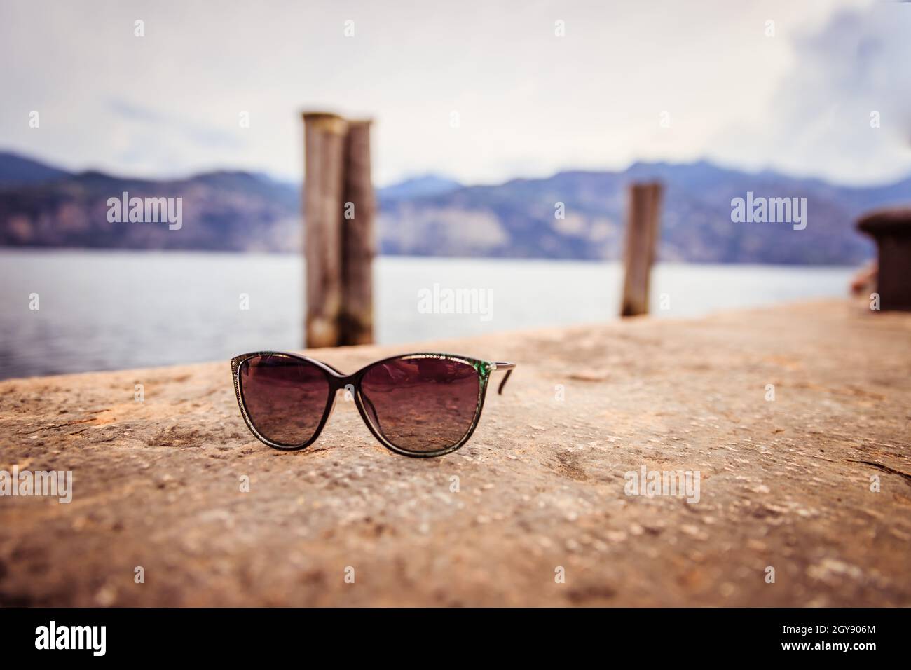 Italian harbour scene: Sunglasses on the stony ground Stock Photo - Alamy