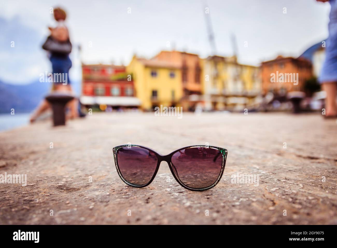 Italian harbour scene: Sunglasses on the stony ground Stock Photo - Alamy