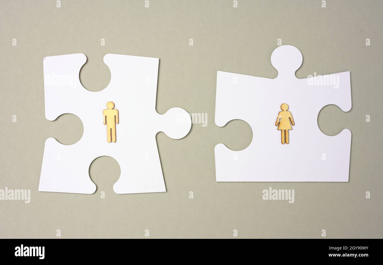 white puzzles and wooden men on a gray background. Recruitment concept ...