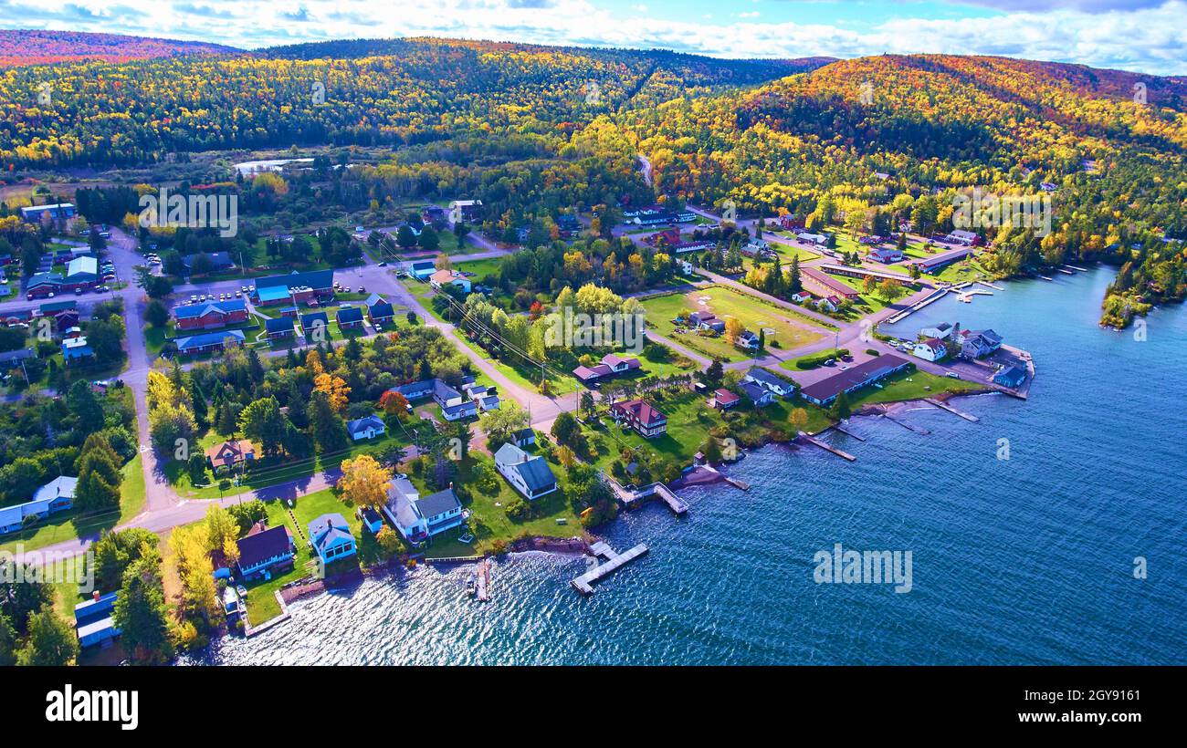 Aerial of Copper Harbor town with fall trees of red orange yellow and ...