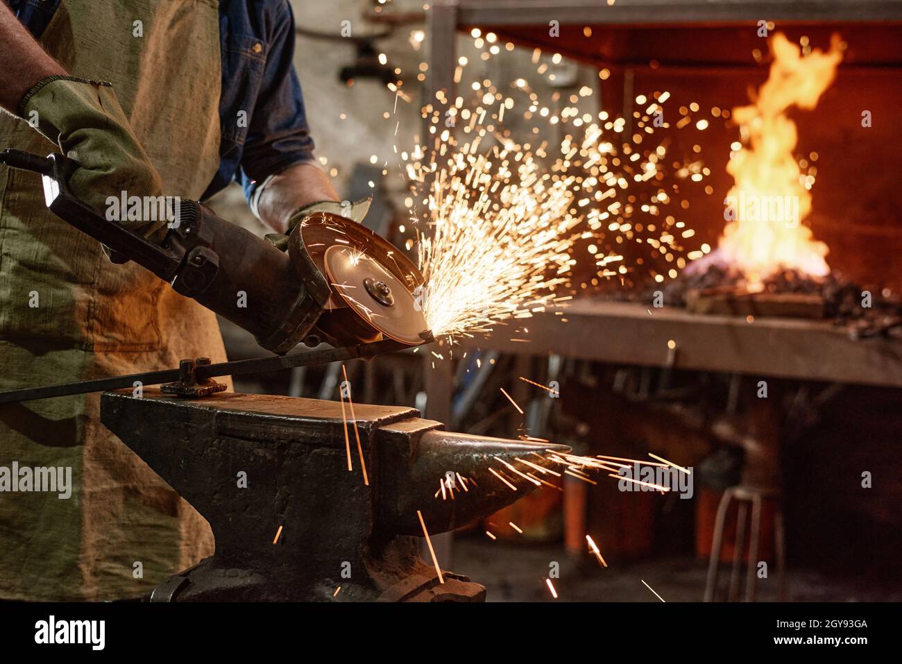 Close-up of man grinding metallic details with electric grinder in the ...