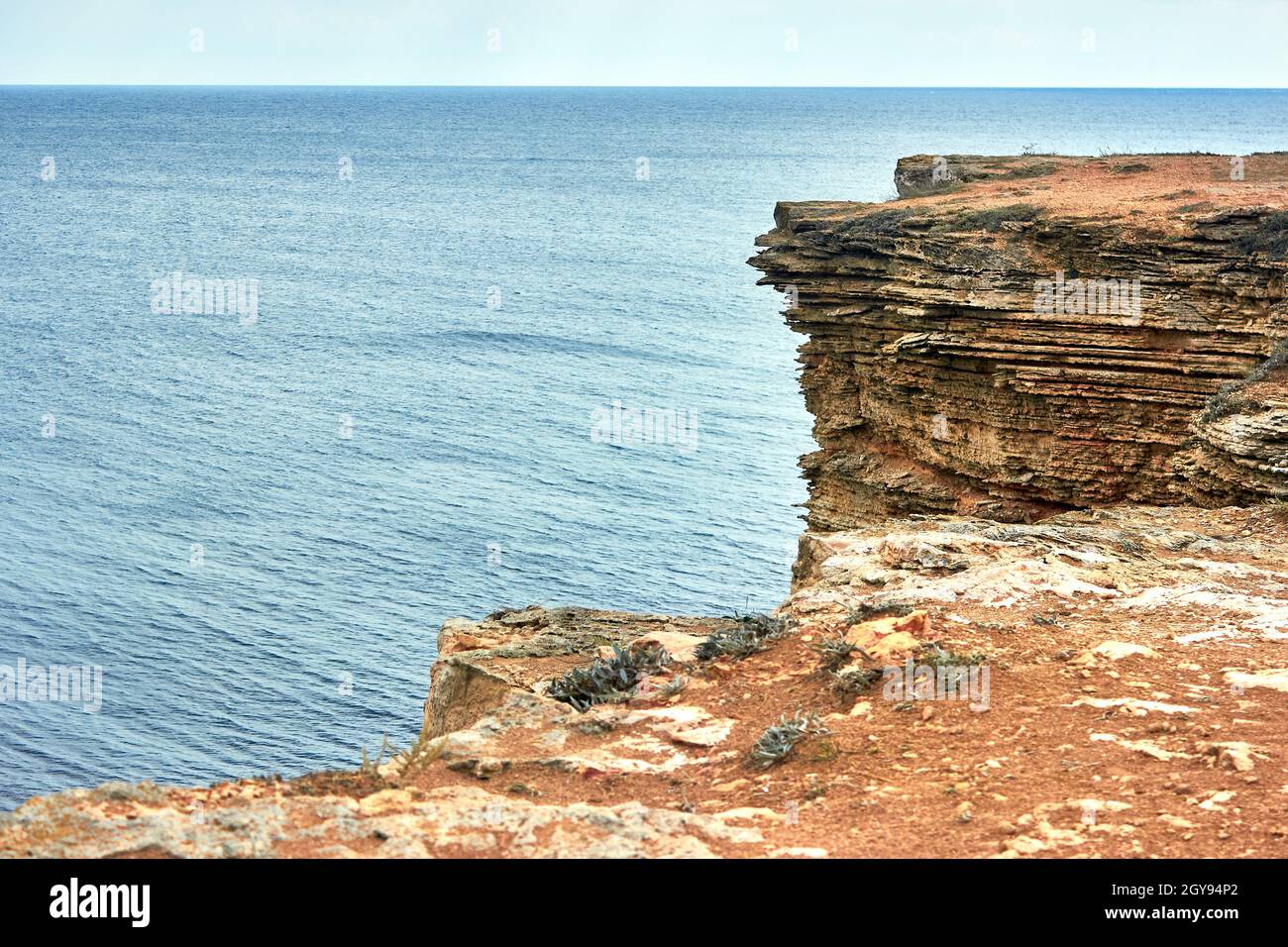 Yellow rocky seashore, cliff. Blue deep calm sea. Calm blue sky. Top ...