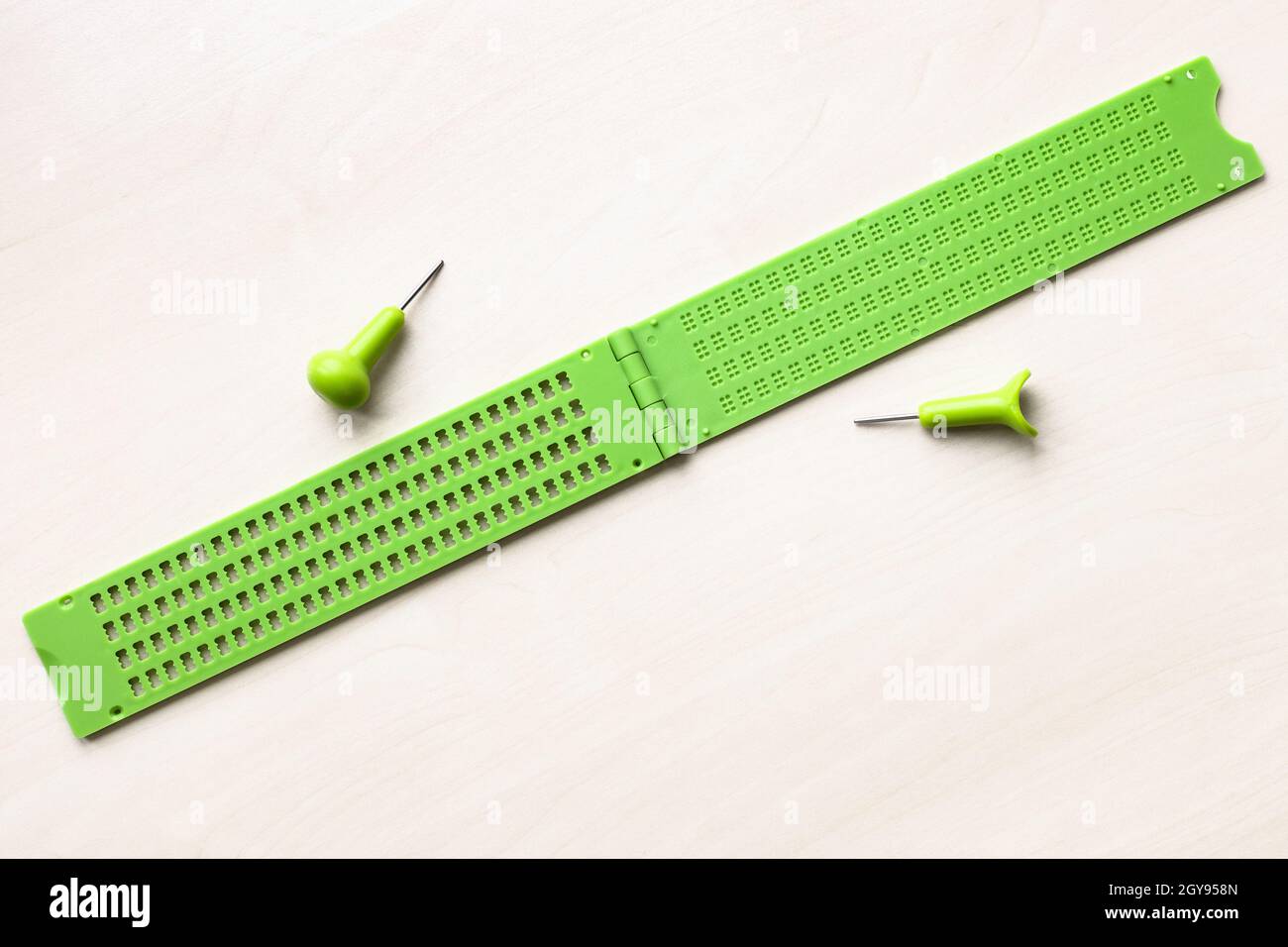 top view of open empty plastic braille writing slate and stylus on ...