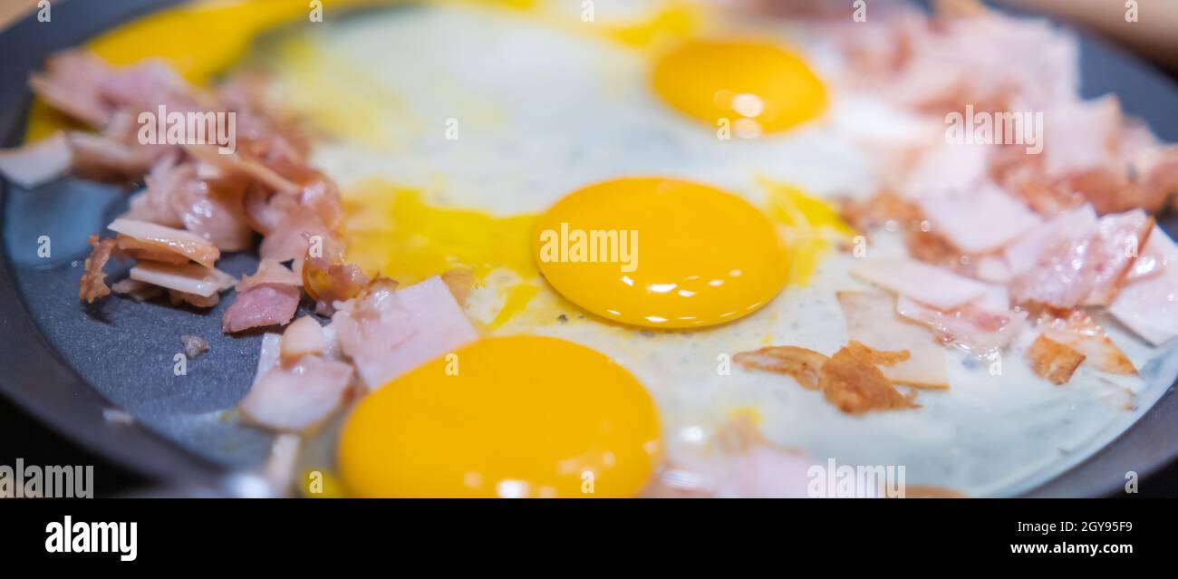 Chopped turkey ham and three egg yolks on a round griddle Stock Photo ...