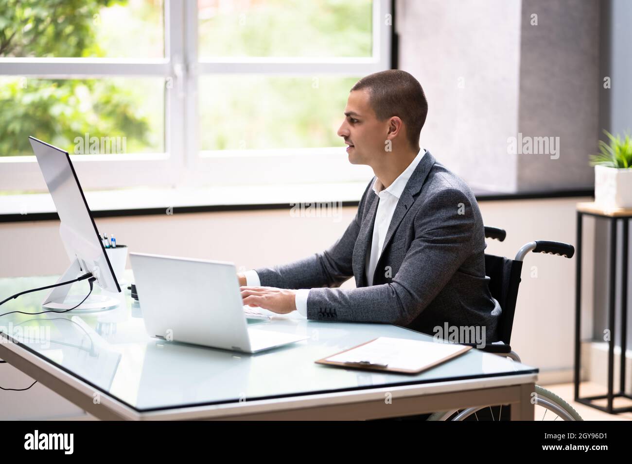 Handicapped Businessman Using Laptop Computer In Office Stock Photo - Alamy