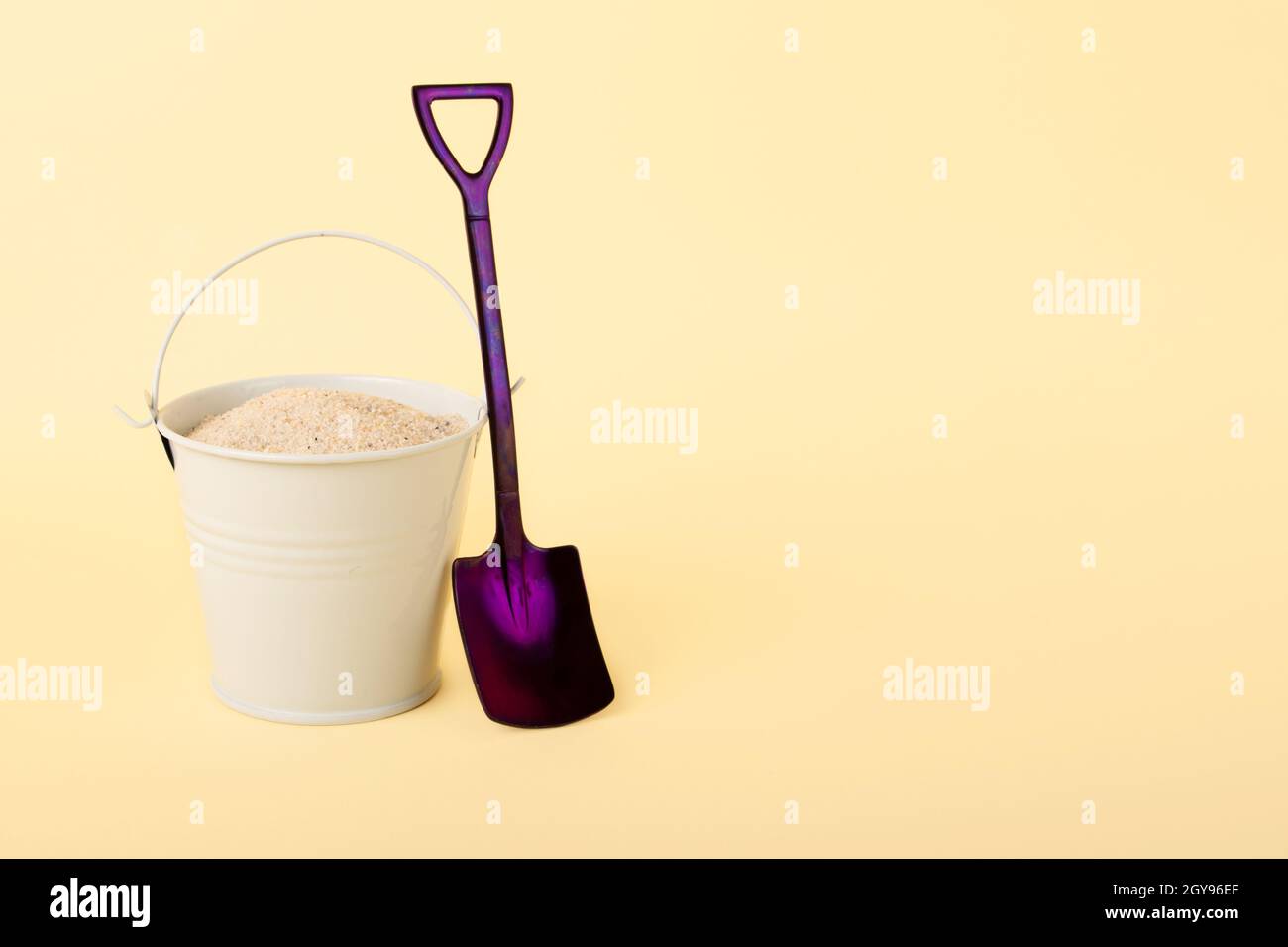 Decorative shovel and bucket,full of quartz sand on the yellow ...