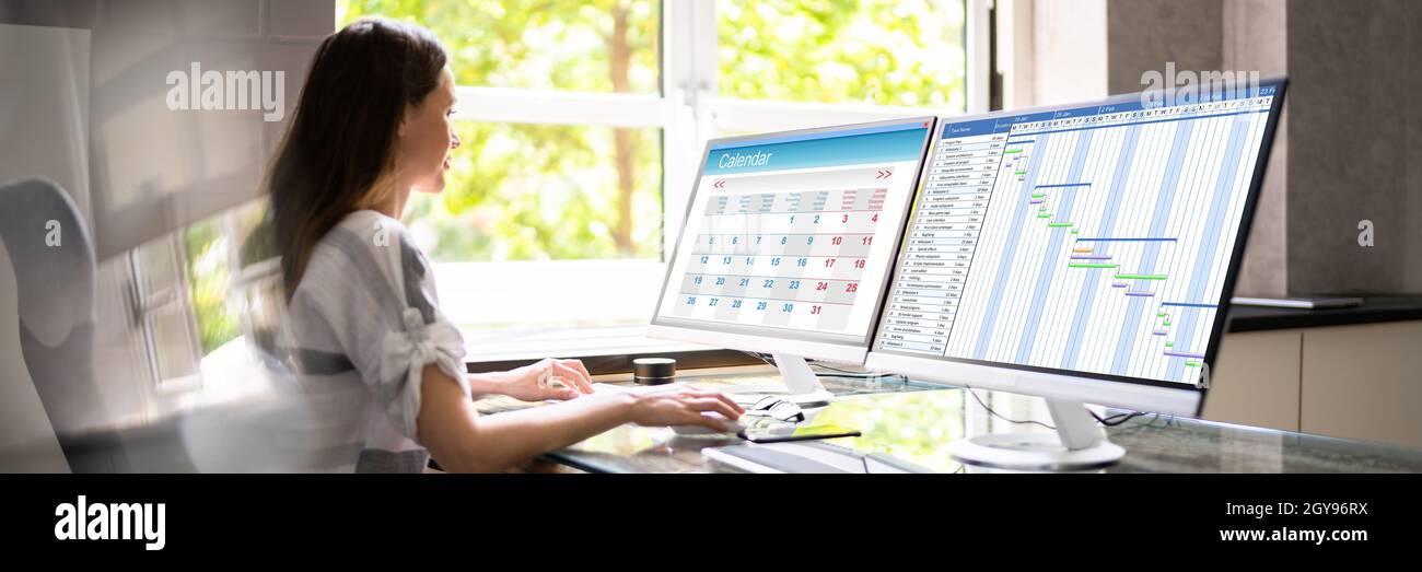 Woman Scheduling Calendar On Multiple Computer Screens Stock Photo - Alamy