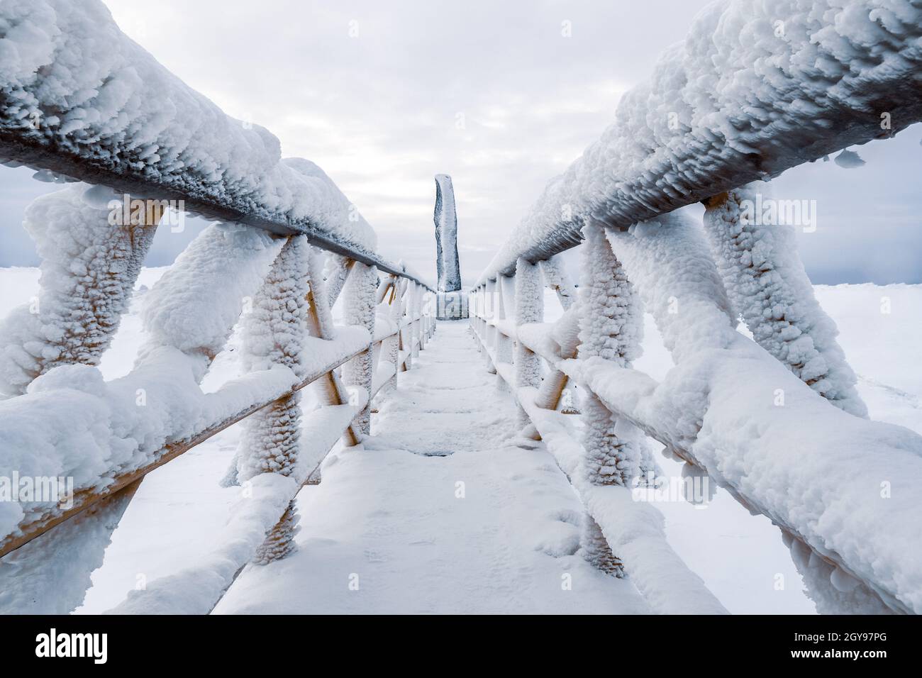 Metal bridge with handrails covered with snow and ice. Extremely cold ...
